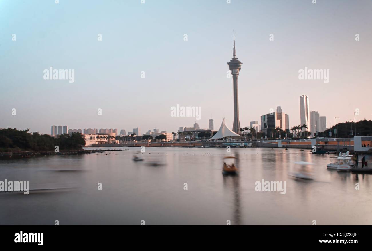 A distant view of the Macau Tower with buildings and water in the ...