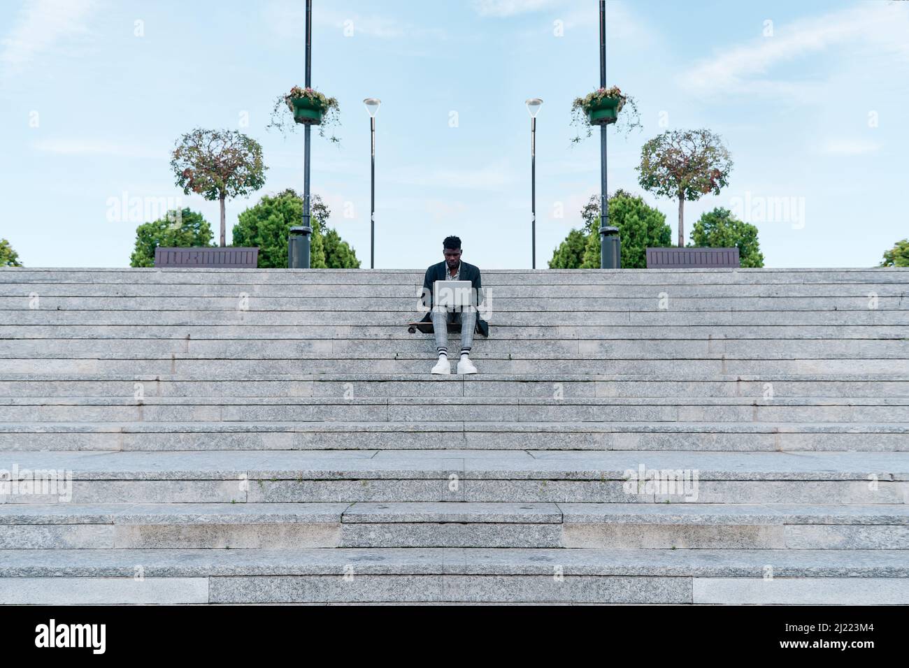 African American man in suit working on laptop computer sitting on ...
