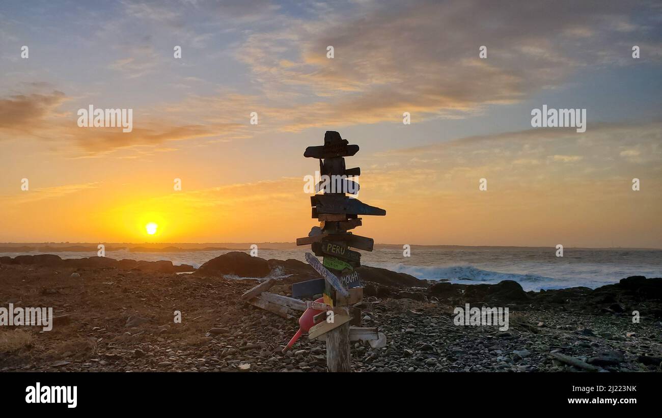 The wooden pole with direction signs against the sunset. Cape Forchu ...