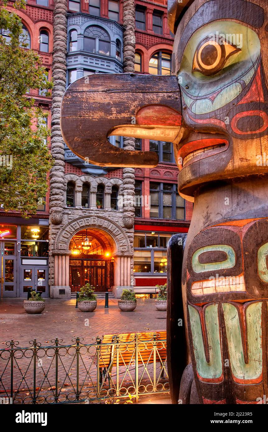 Totem pole on street with historic apartment building behind Stock ...