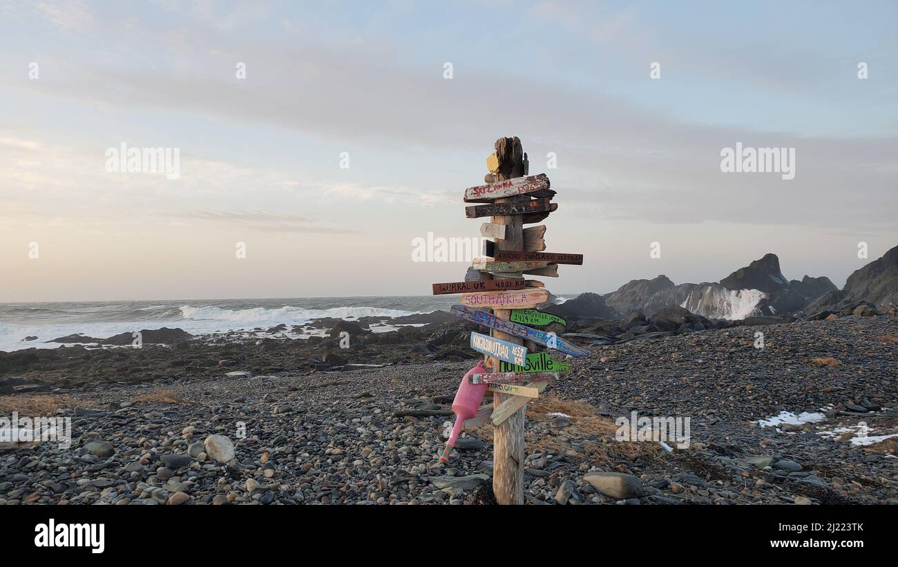 The wooden pole with direction signs against the sky. Cape Forchu ...