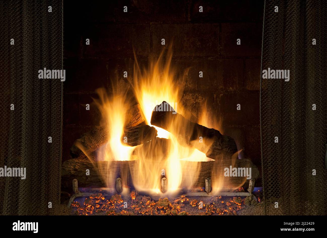 A domestic fireplace, hearth, fire lit, logs and flames Stock Photo - Alamy