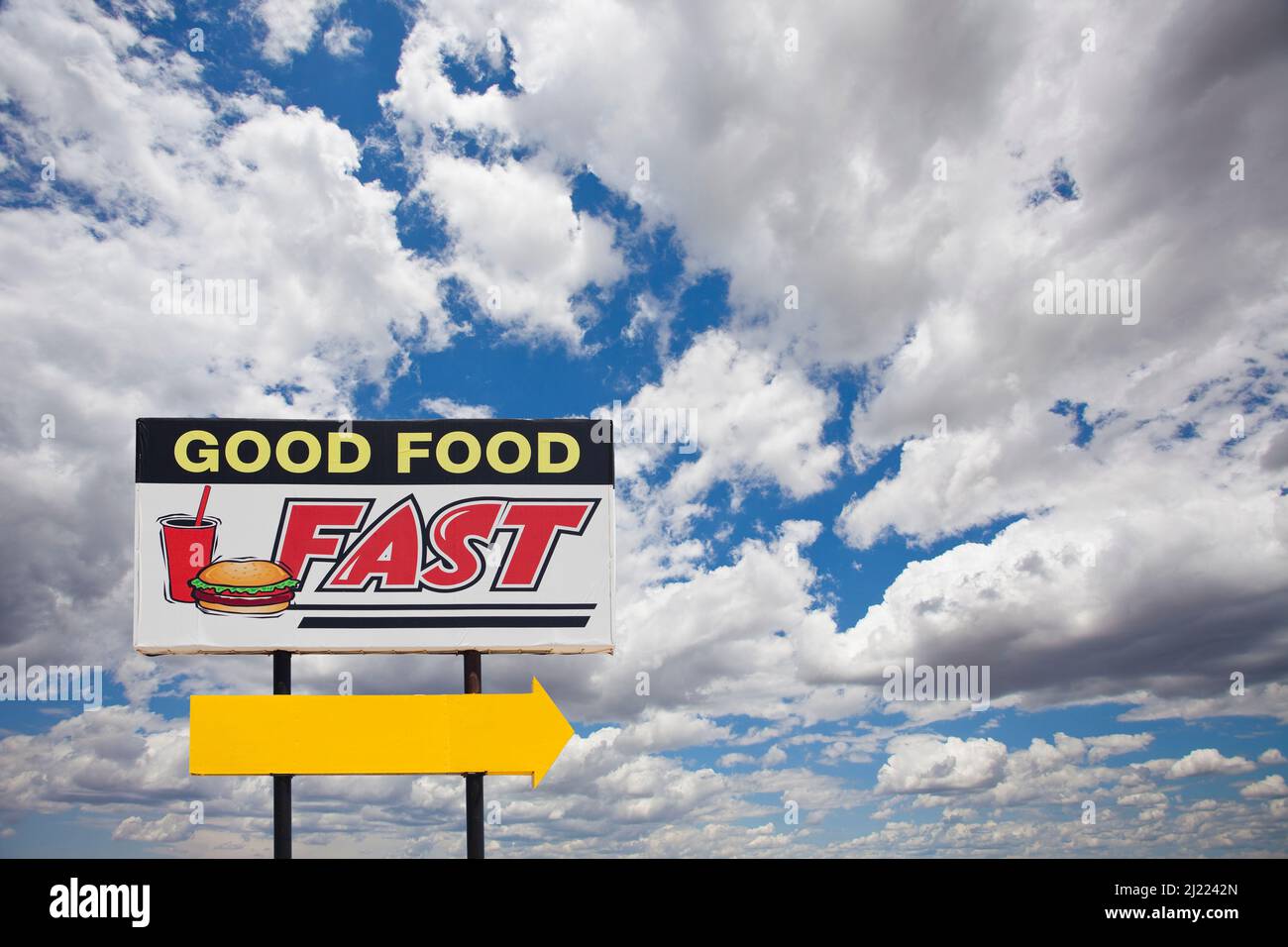 Fast food sign by the road, Good Food Fast and a yellow arrow Stock ...