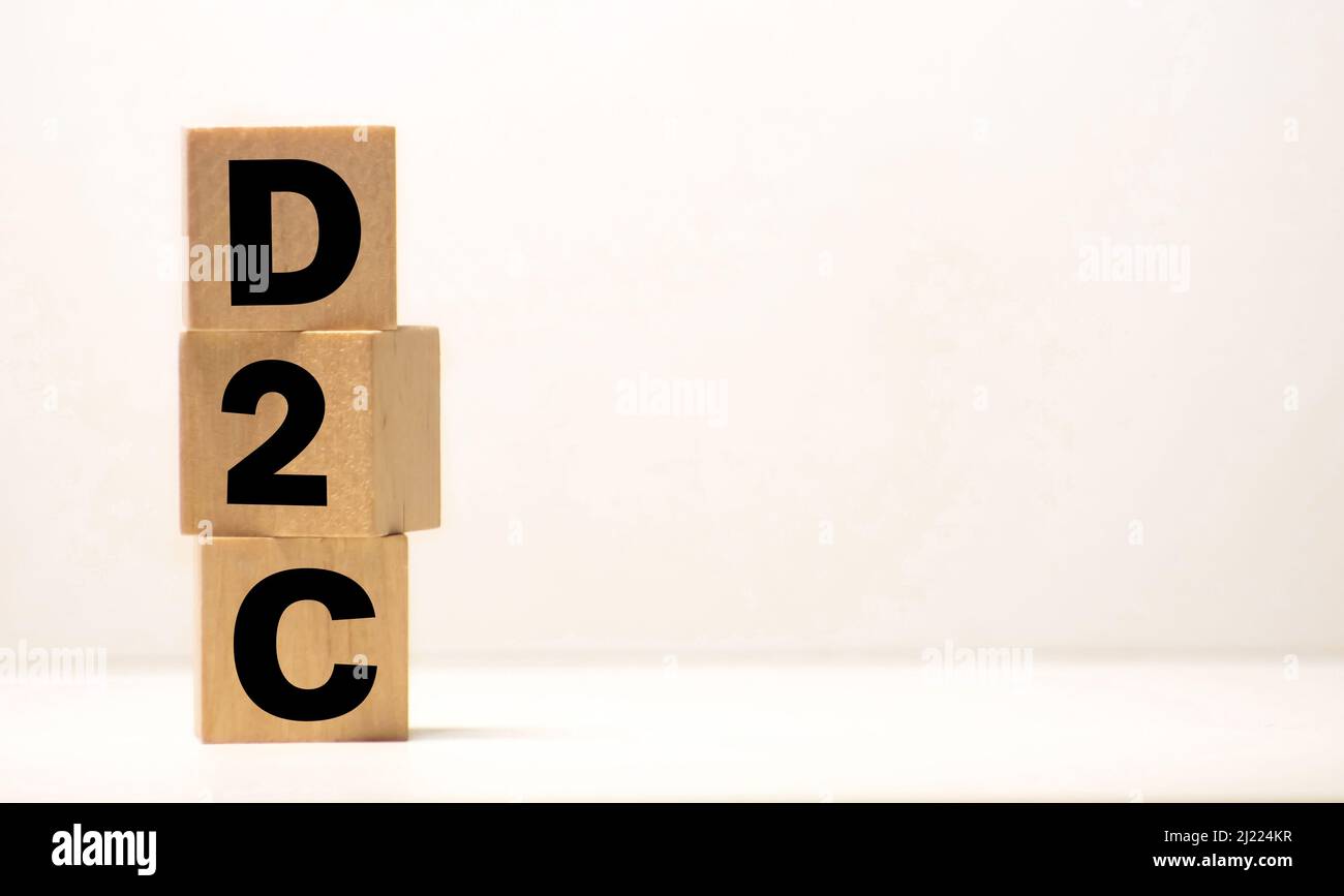 D2C word concept written on wooden blocks, cubes on a table with flower ...