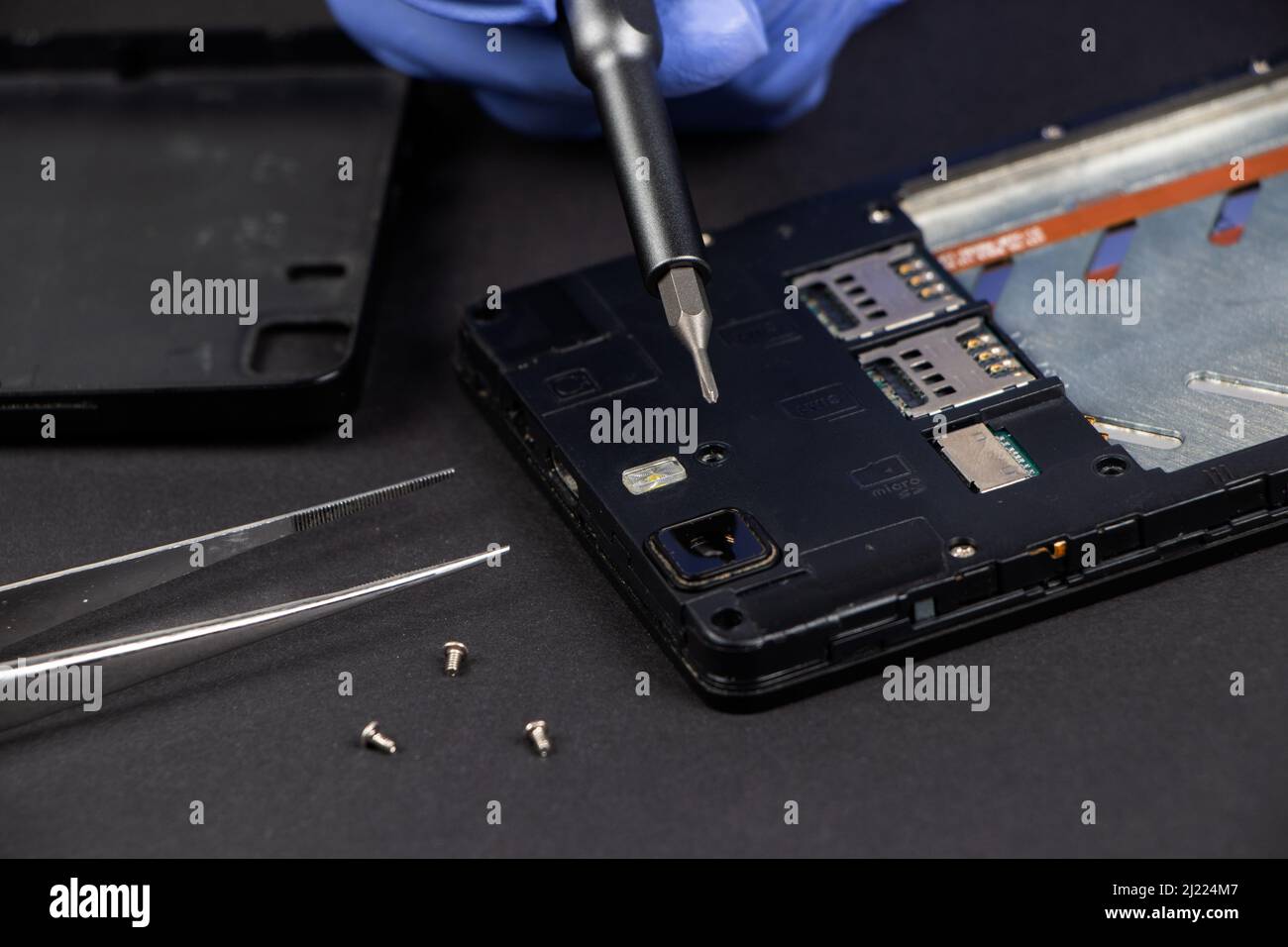 Process of mobile phone repair. Hands of a service worker repairing ...