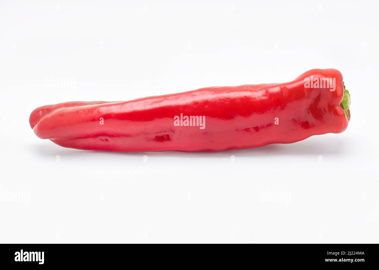 a single red pepper from the side on a white background Stock Photo - Alamy