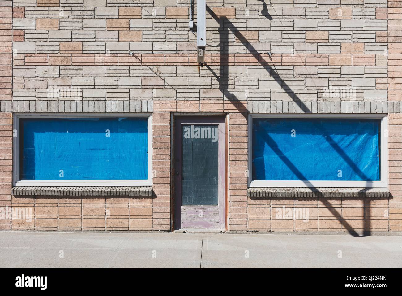 Empty building with covered windows, and an empty sign frame Stock ...