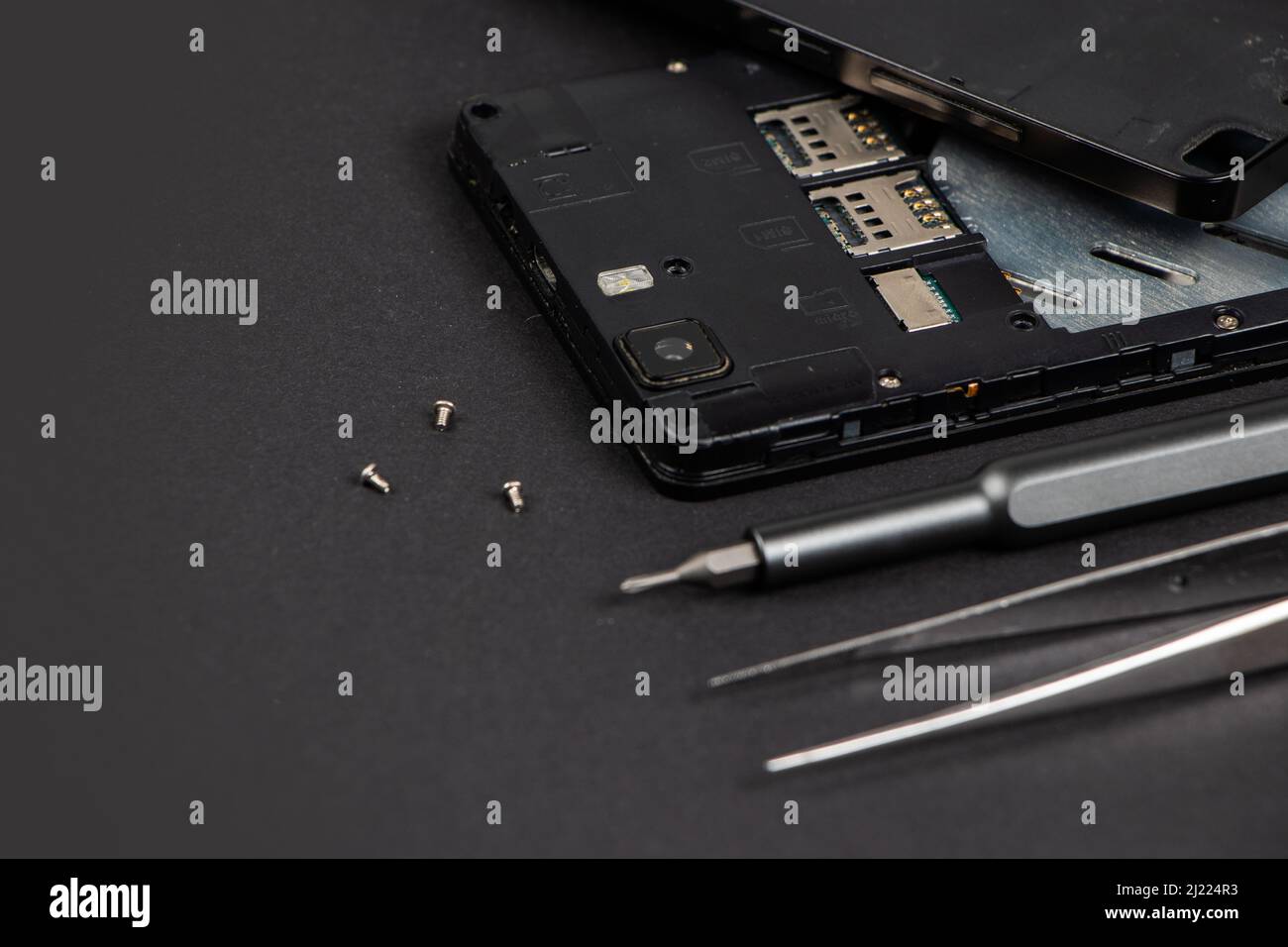 Broken mobile phone and repair tools on dark background, flat lay Stock ...