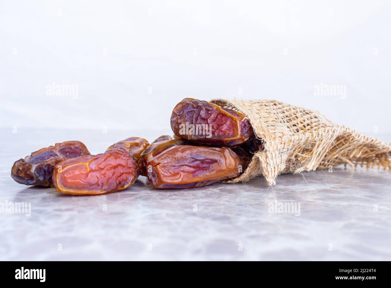 Poured dates top view. Dried date fruits in sack bag on marble ...