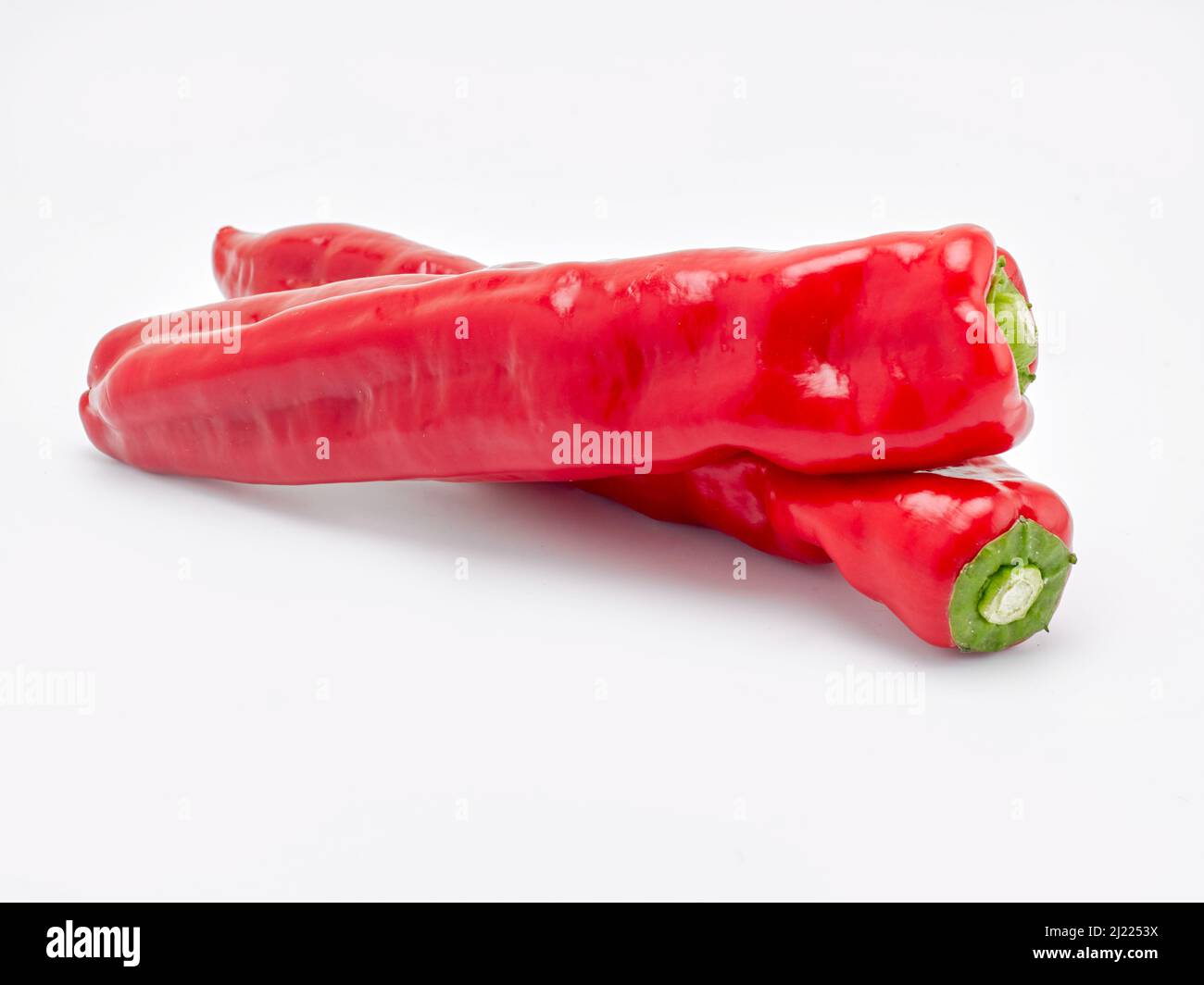two red peppers on a white background Stock Photo - Alamy