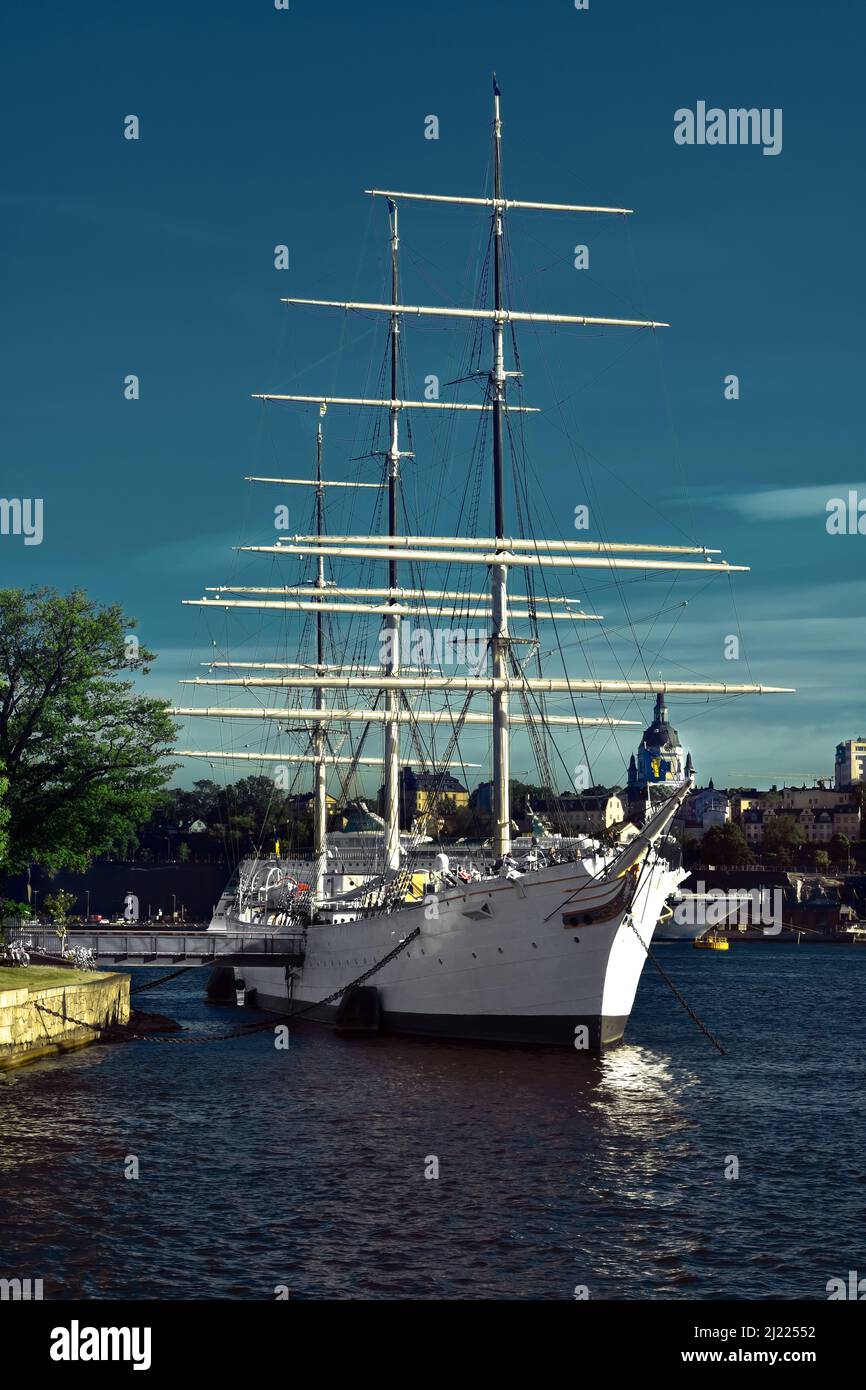 A vertical beautiful view of a big white ship with high masts sailing ...