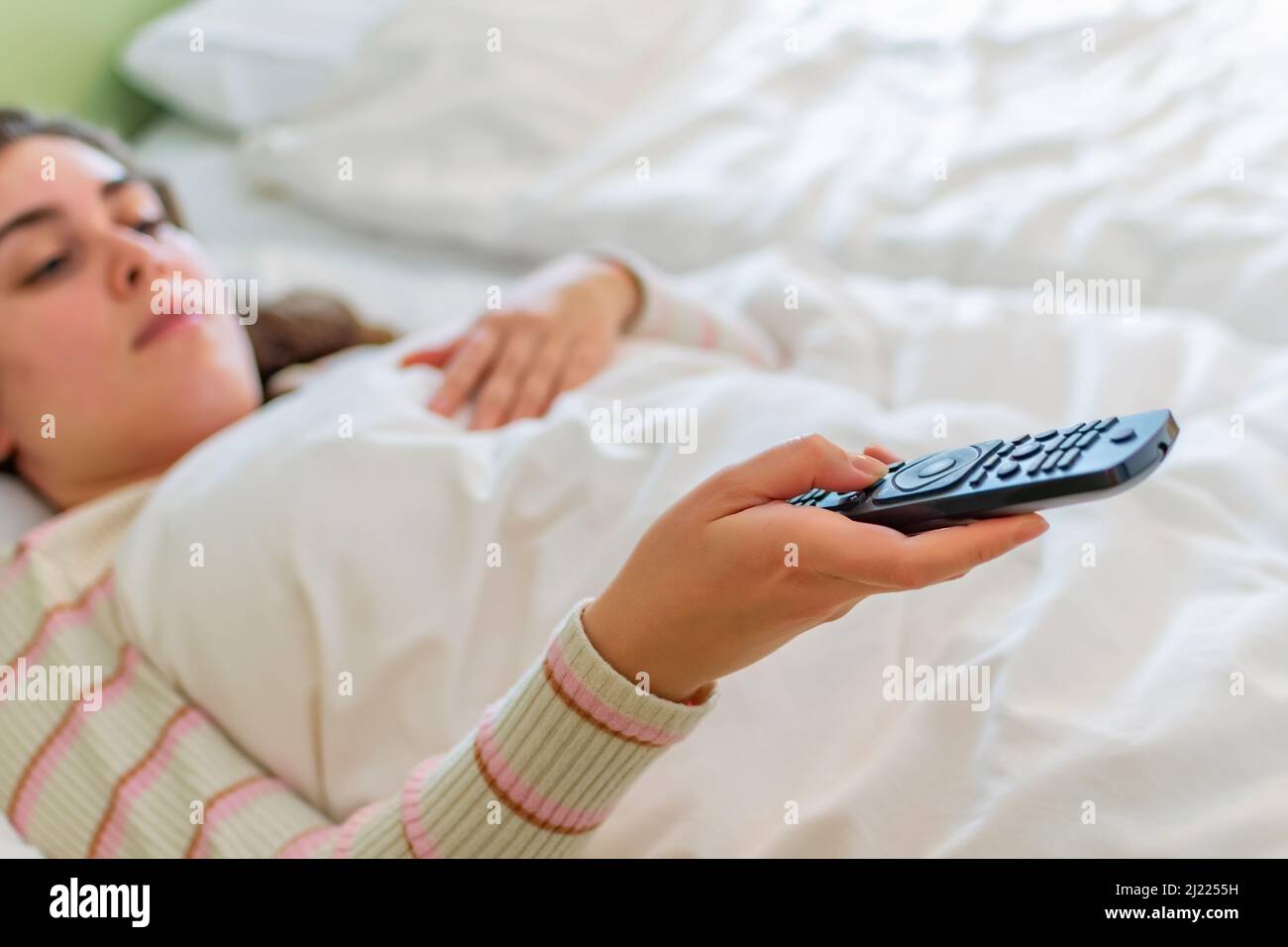 TV remote in a female hand close up. Woman watching TV Stock Photo - Alamy