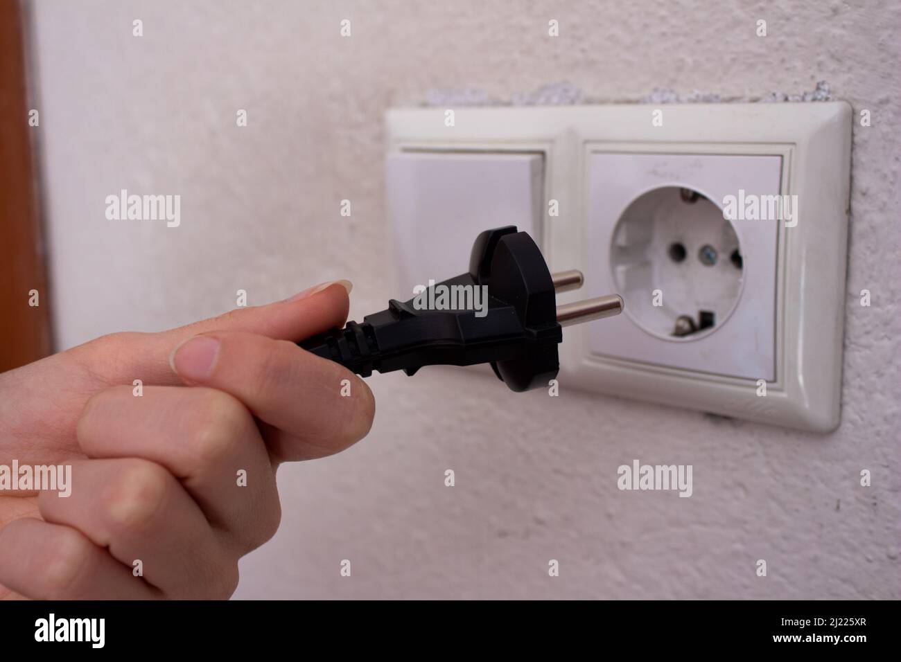 Closeup hand inserting the plug into the outlet Stock Photo - Alamy