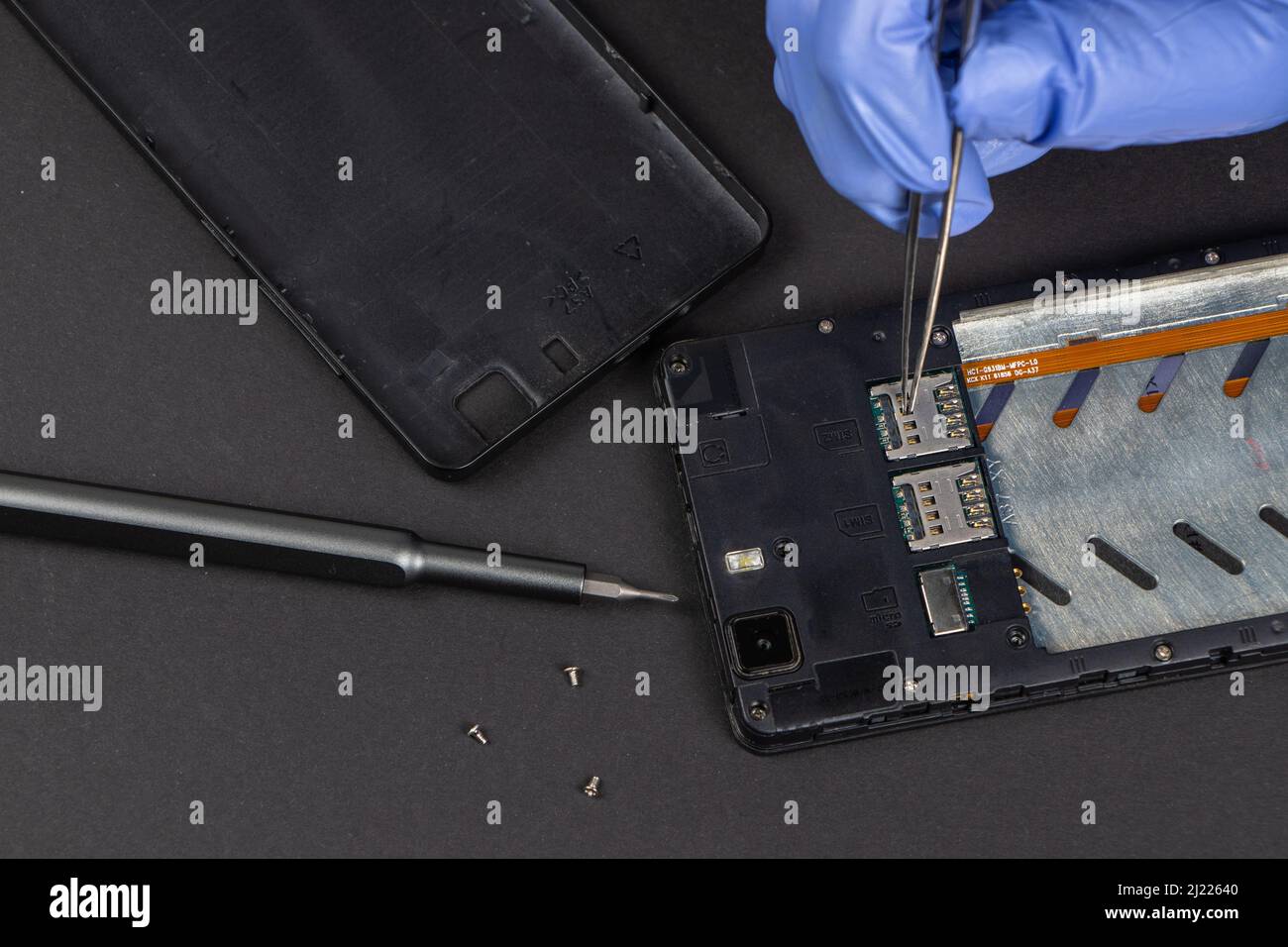 Process of mobile phone repair. Hands of a service worker repairing ...