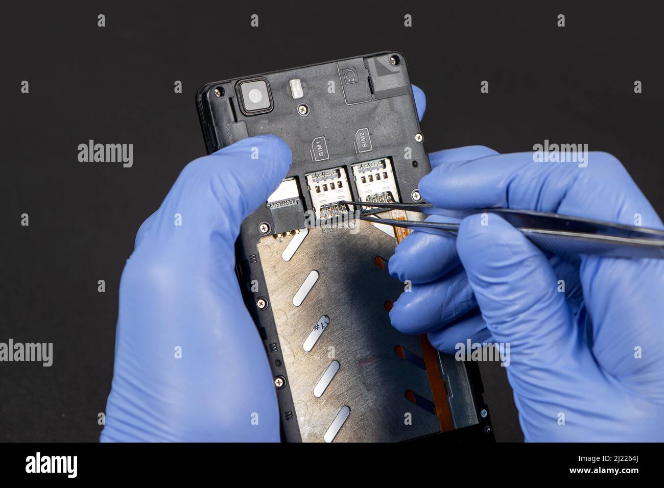 Process of mobile phone repair. Hands of a service worker repairing ...