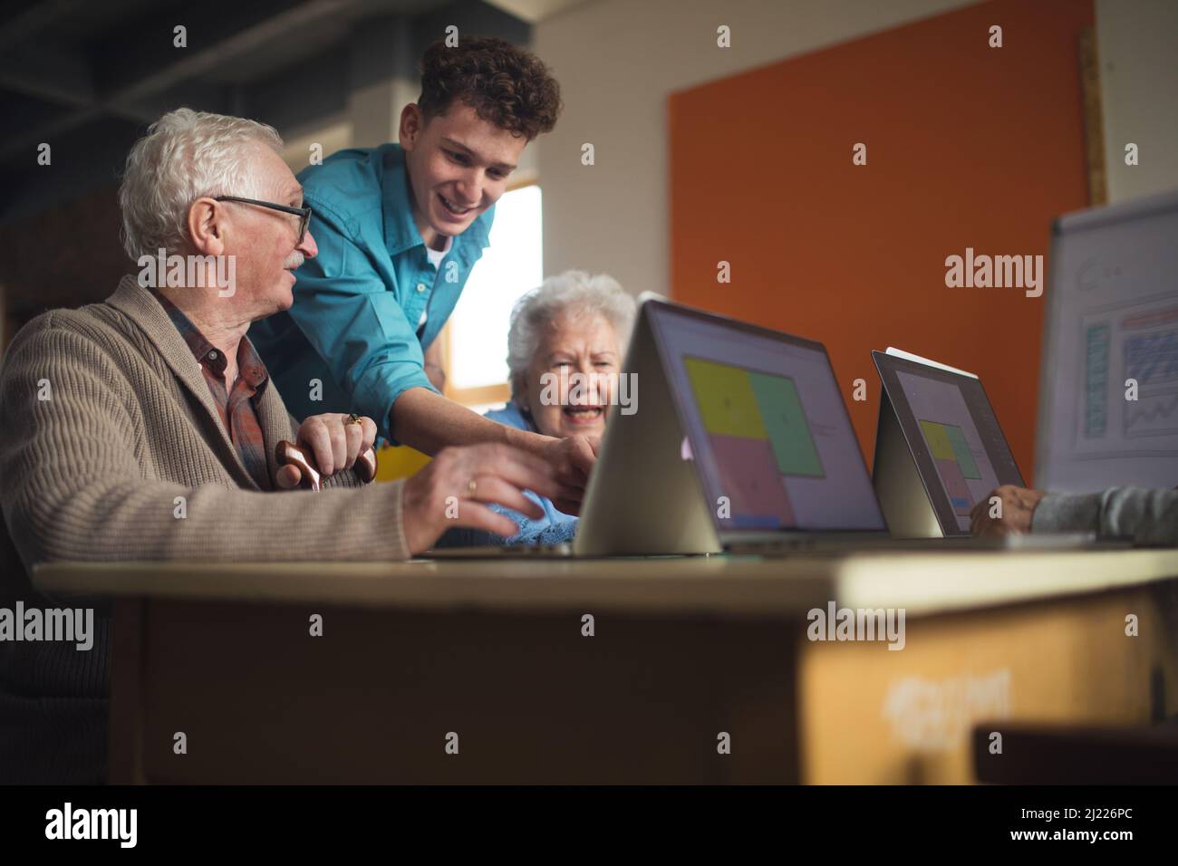 Senior group in retirement home with young instructor learning together ...