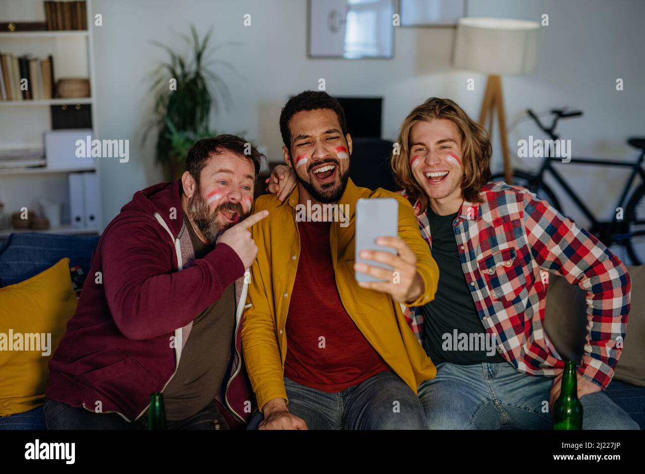 Happy Austrian football fans friends watching football at home and ...