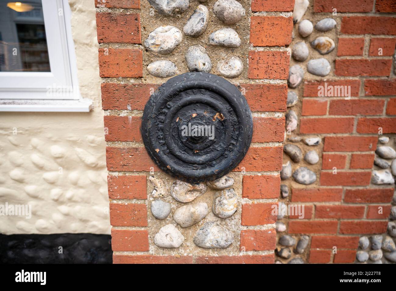 Old black discs/ pattress on side of a building/ houses to help ...