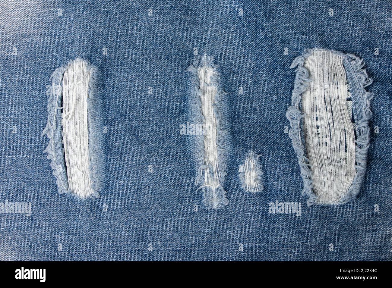 White stitching on blue denim jeans patch. Close up blue jean frame ...
