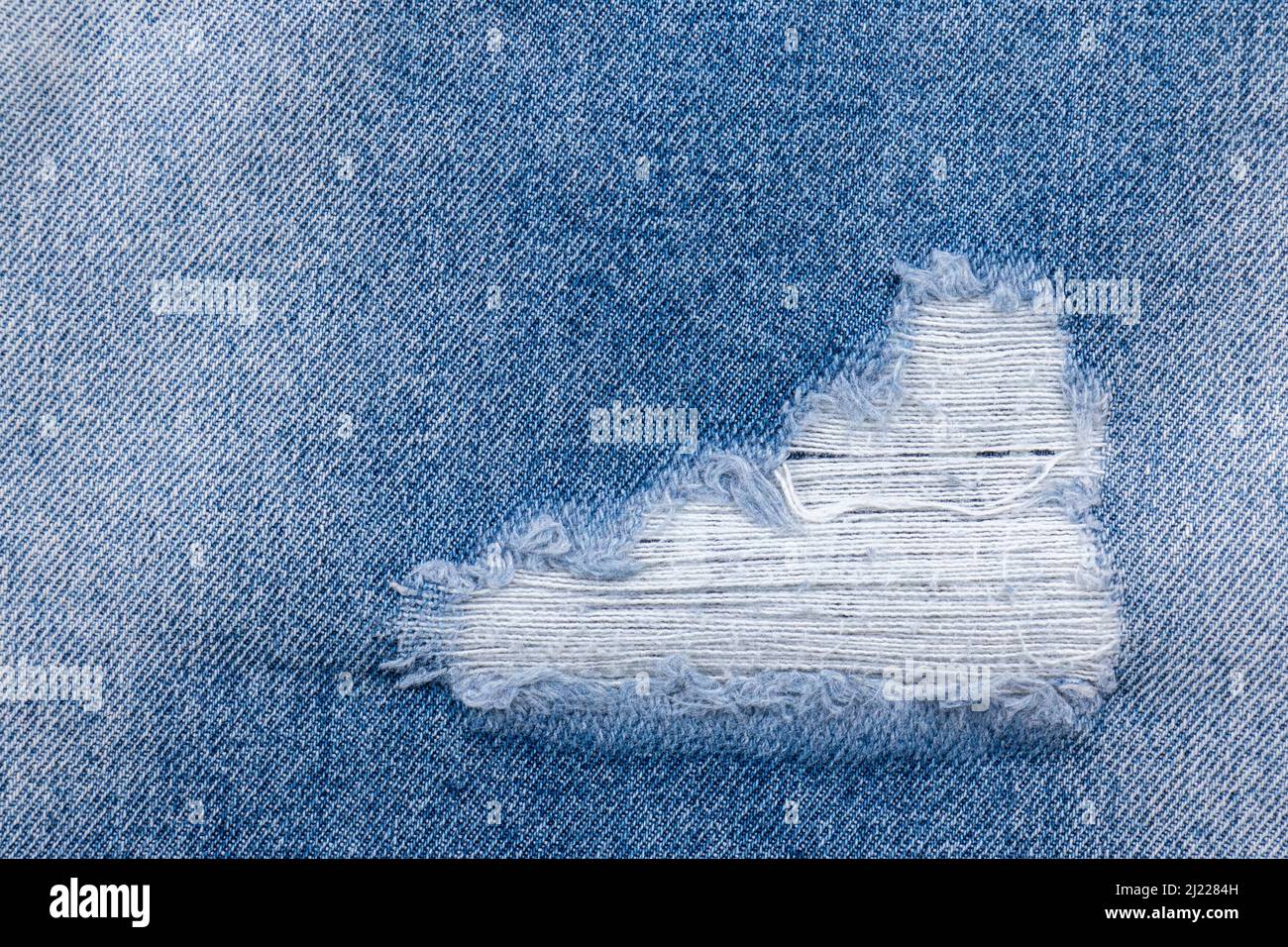 White stitching on blue denim jeans patch. Close up blue jean frame ...