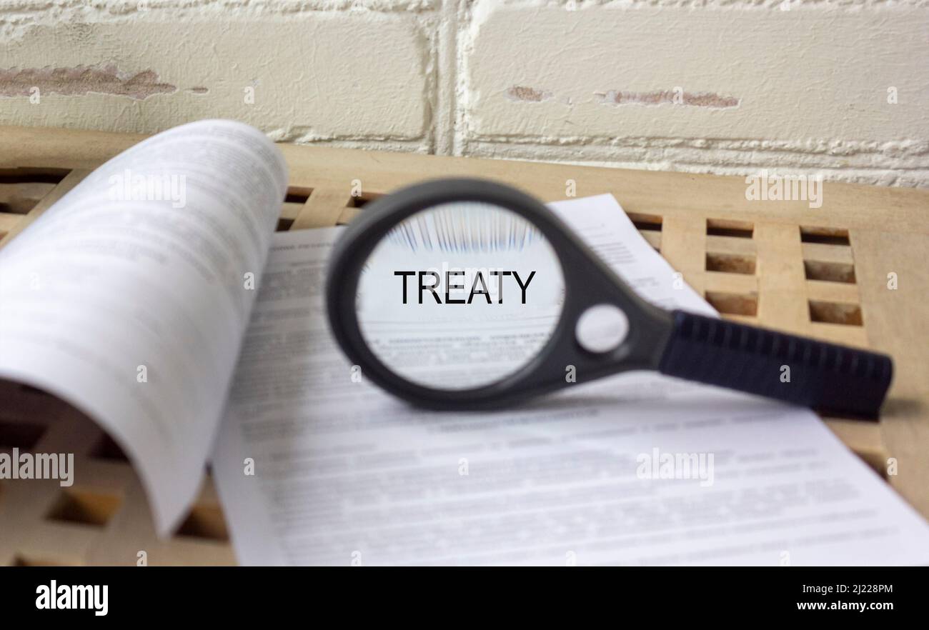 Word TREATY through a magnifying glass on documents Stock Photo - Alamy