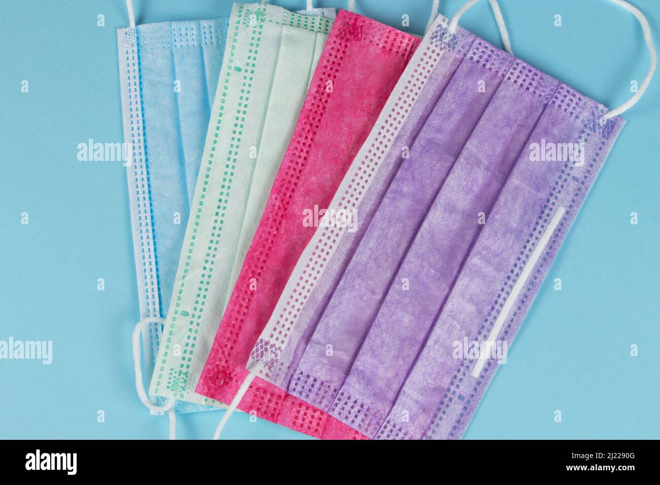 Different colored medical masks on blue background Stock Photo - Alamy