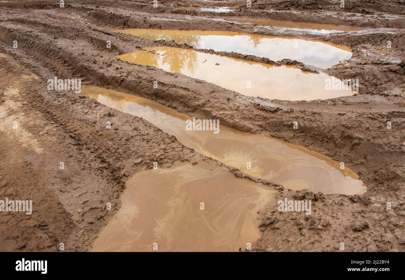 Dirty road. puddle with havy tires track Stock Photo - Alamy