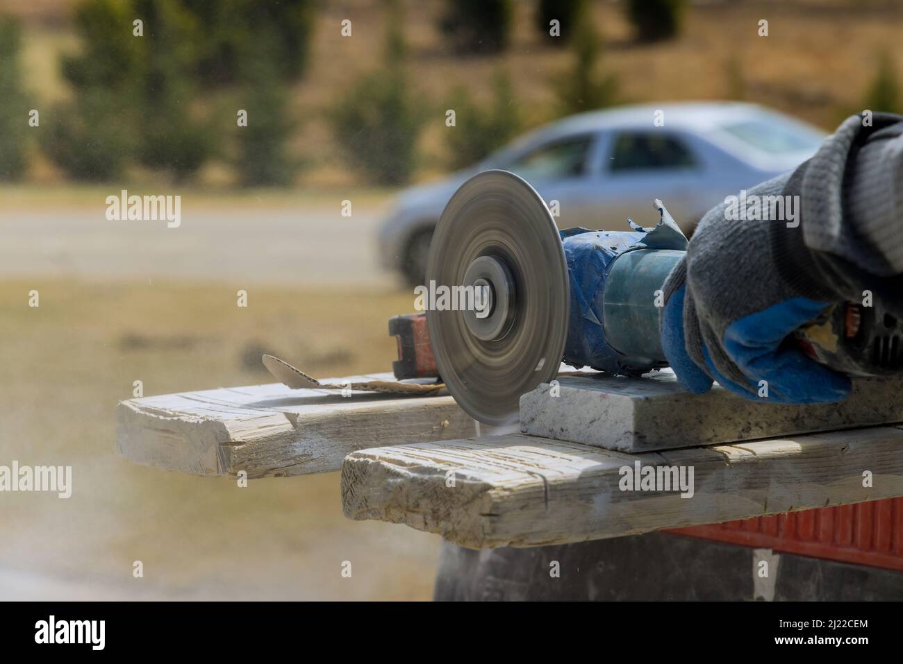 A man cutting marble stones with an angle grinder Stock Photo - Alamy