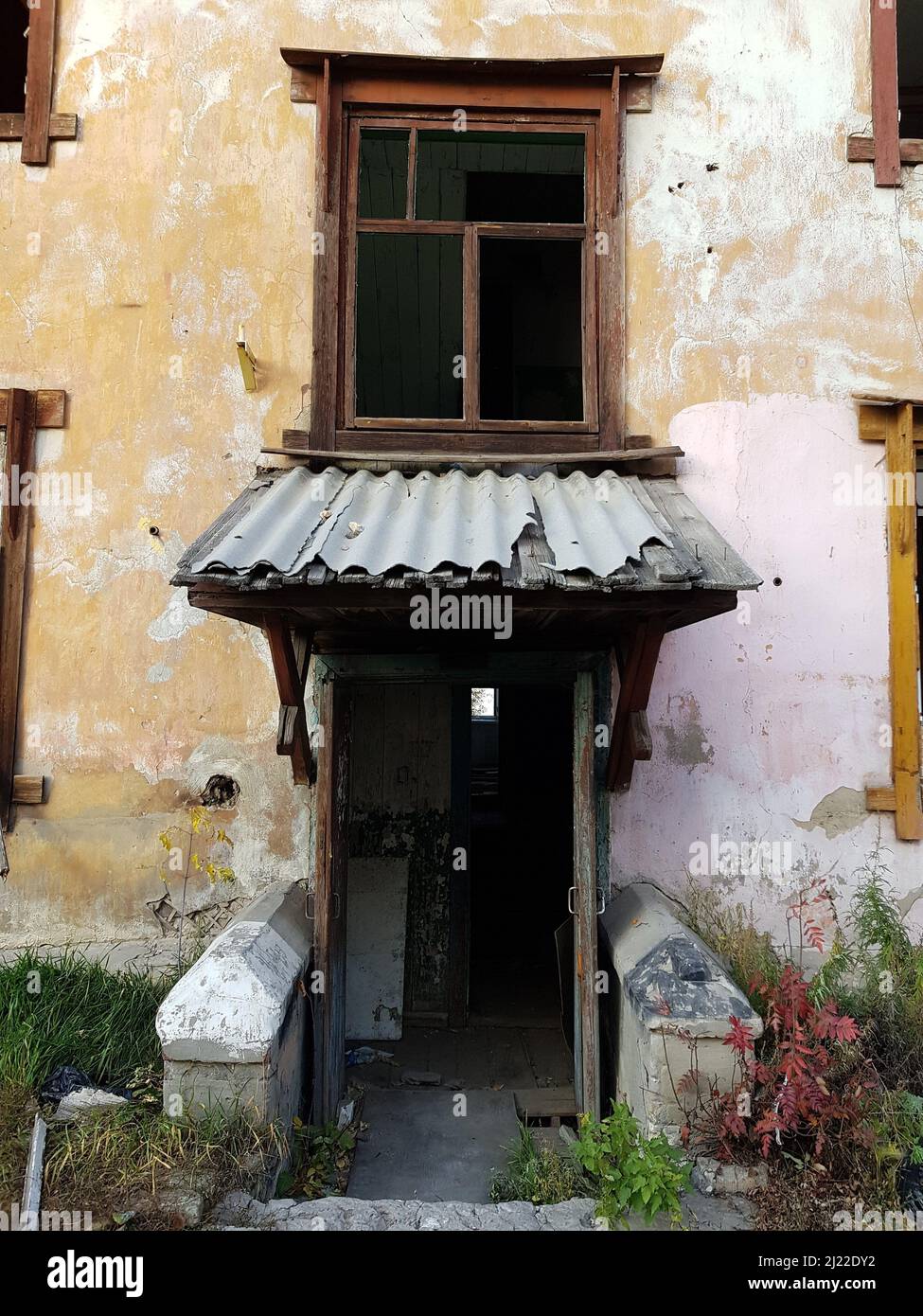 The windows of an old abandoned house with broken glass. An empty ...