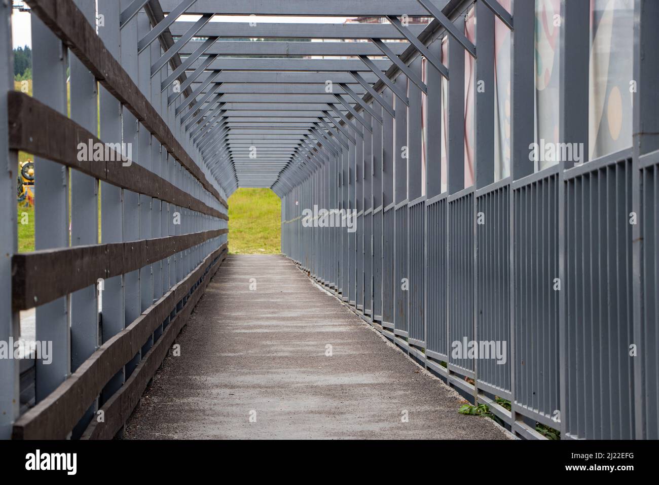 A long pedestrian tunnel with metal arches and mesh design. Aerial ...