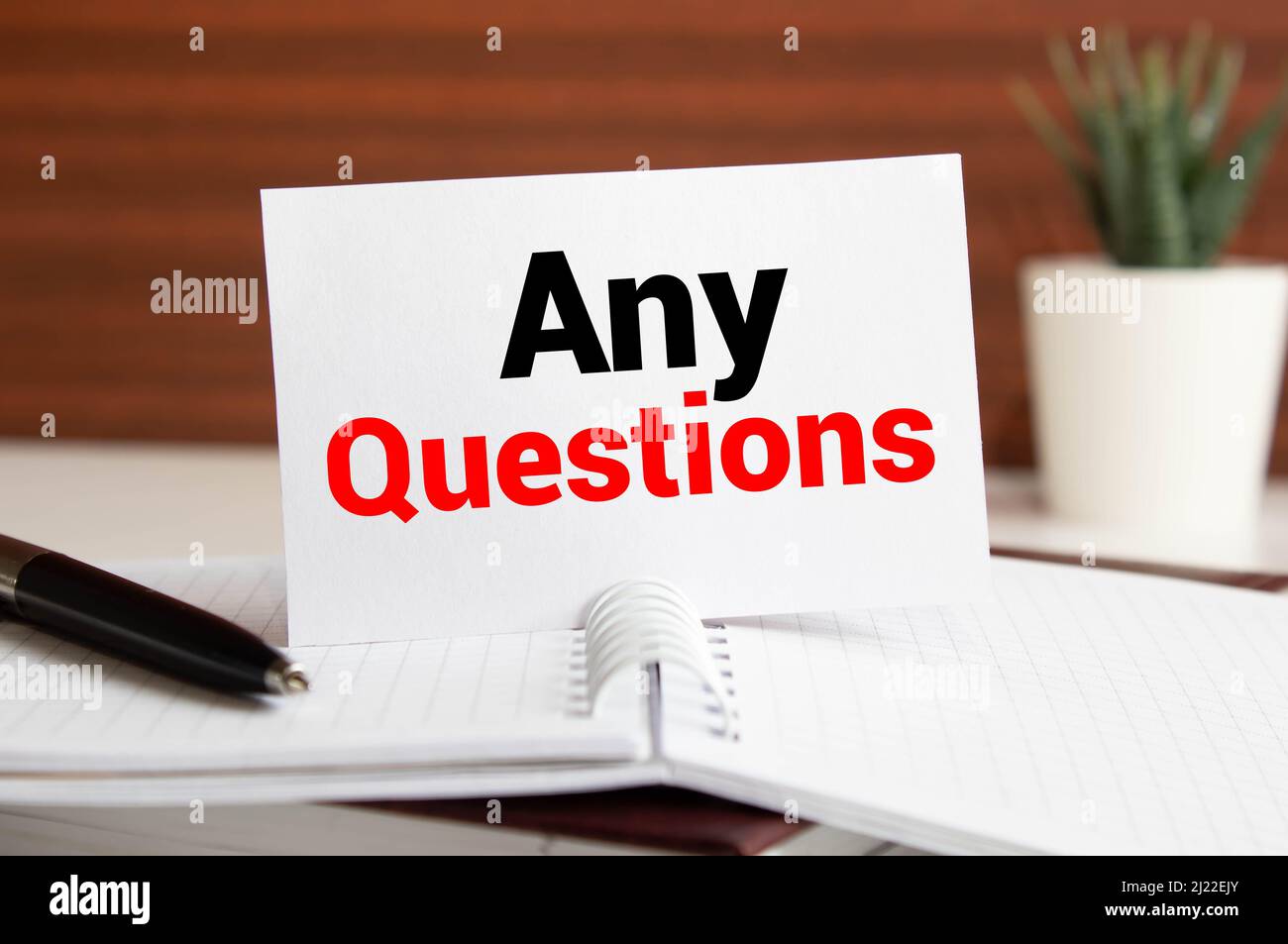 Any Questions word,concept: Torn paper on black background with pen ...