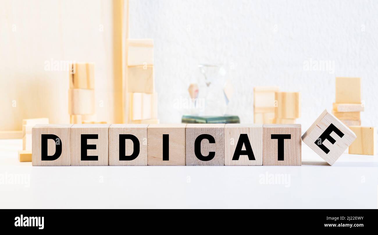 Word Dedicate on a row of wooden blocks. Devotion dedication love concept Stock Photo - Alamy