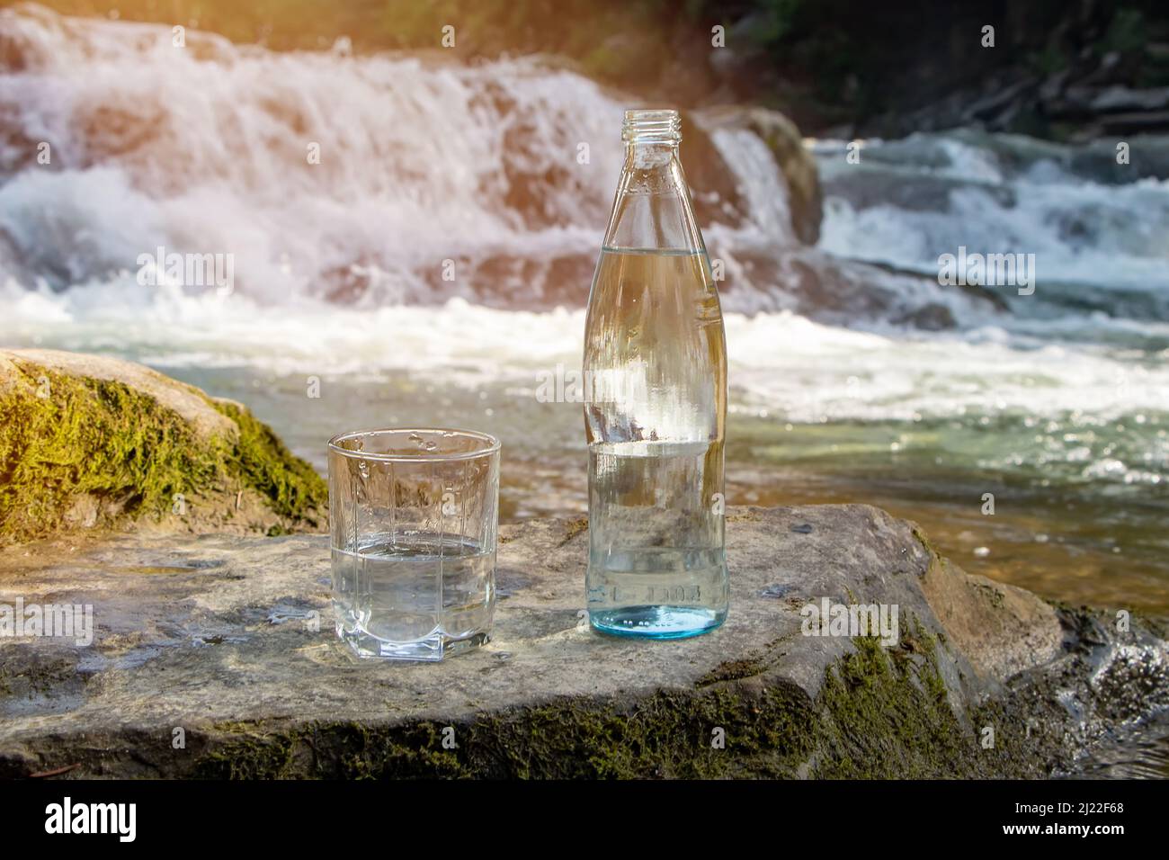 Natural drinking water in a bottle and glass beaker on nature ...