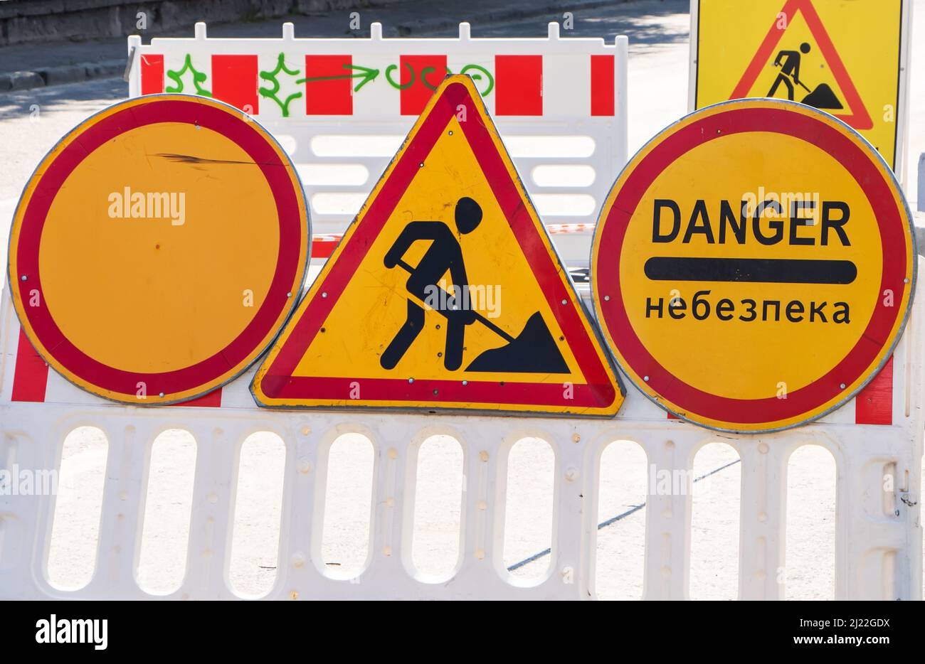 Road works sign hanging on a fence close up Stock Photo - Alamy