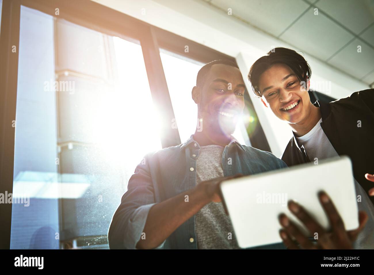 Check out these cool features. Shot of two young colleagues looking at ...