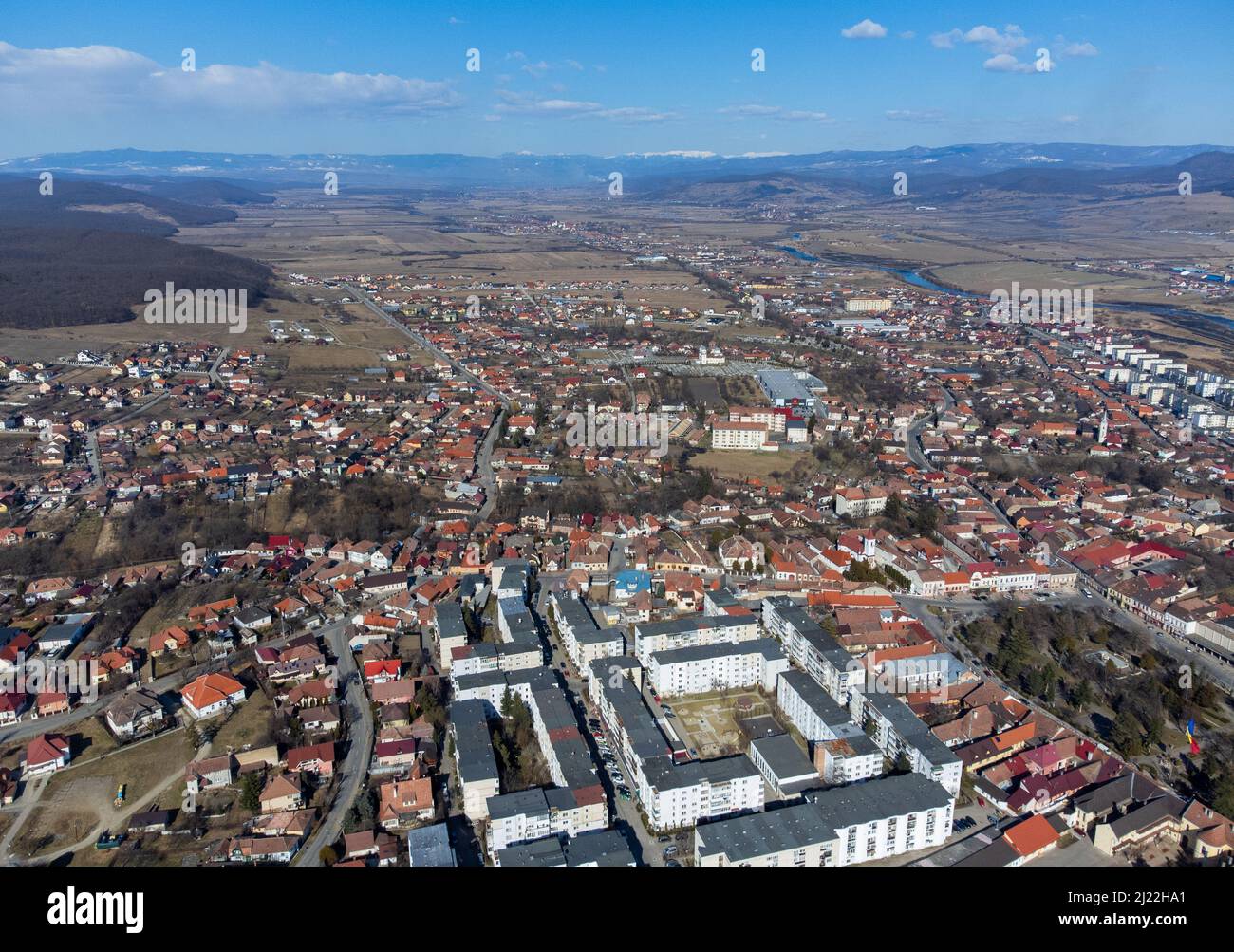 An aerial cityscape view of old and new buildings in Reghin city ...