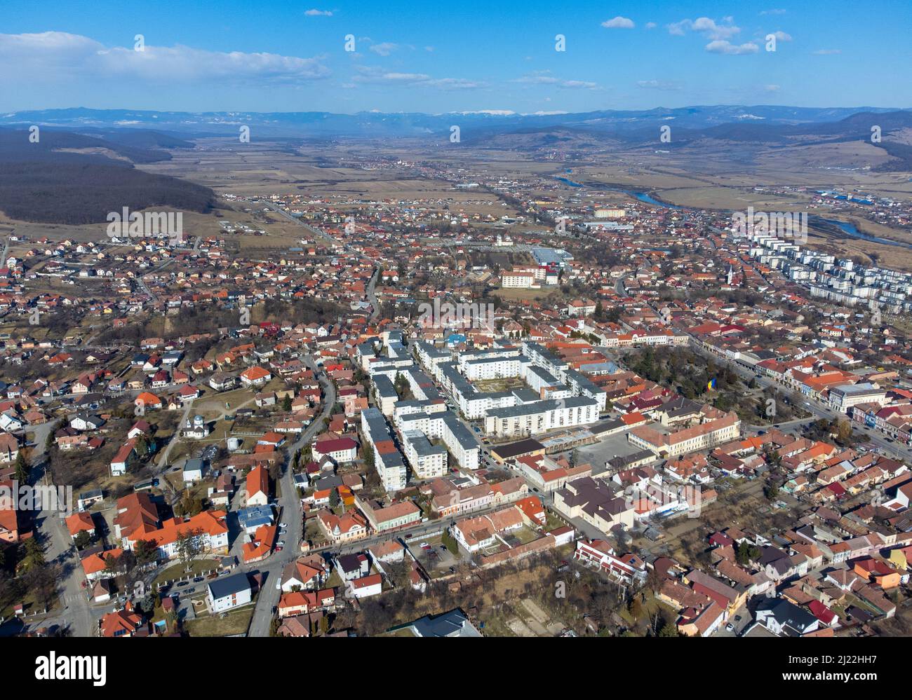 An aerial cityscape view of old and new buildings in Reghin city ...