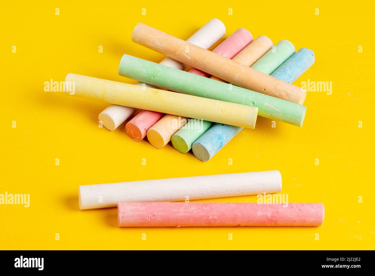 Colorful chalks on yellow background Stock Photo - Alamy