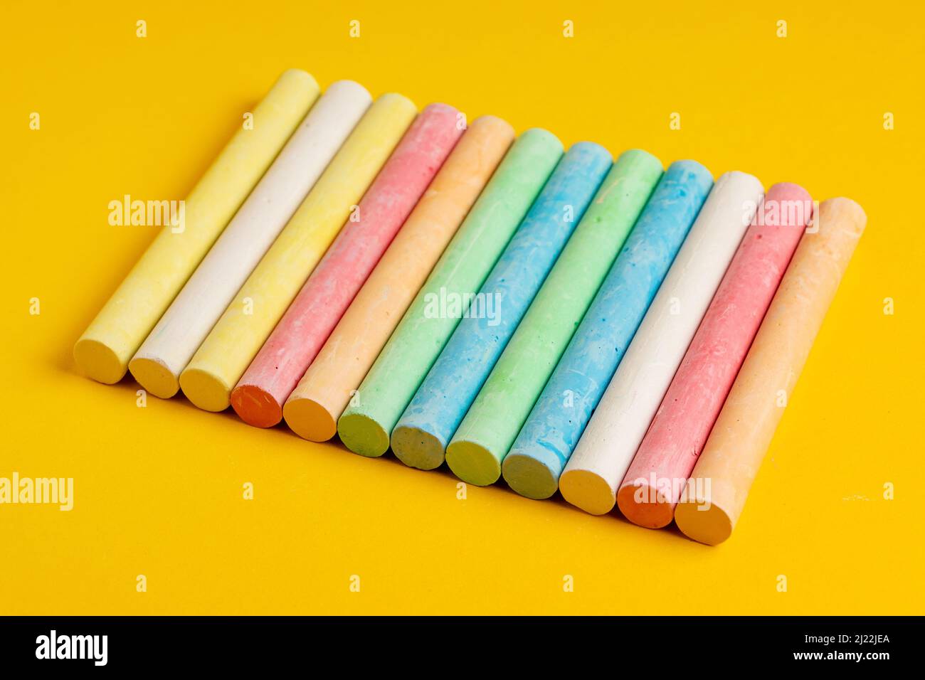 Colorful chalks on yellow background Stock Photo - Alamy