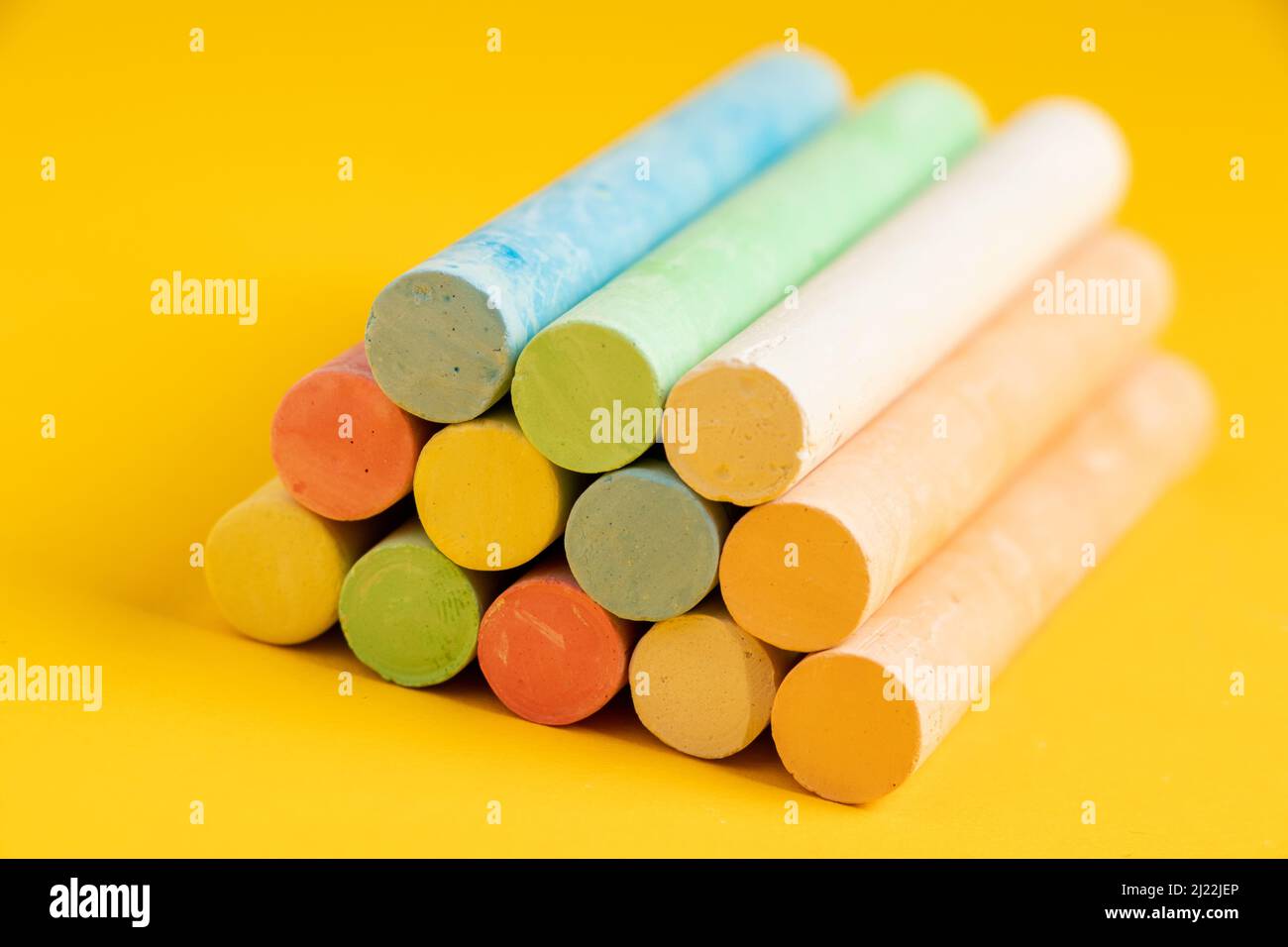 Colorful chalks on yellow background Stock Photo - Alamy