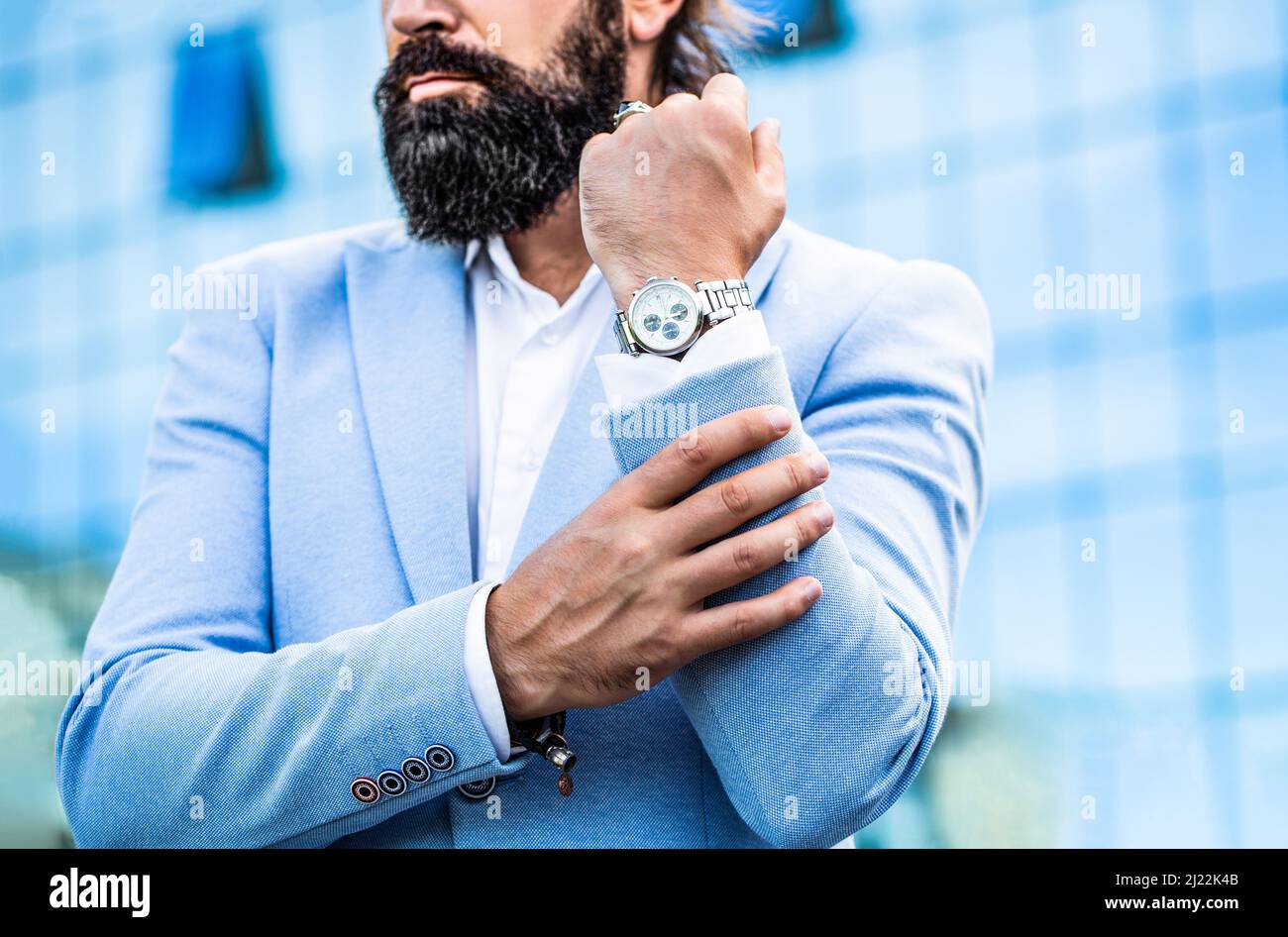 Businessman points to his watch on the background of the town. Man ...