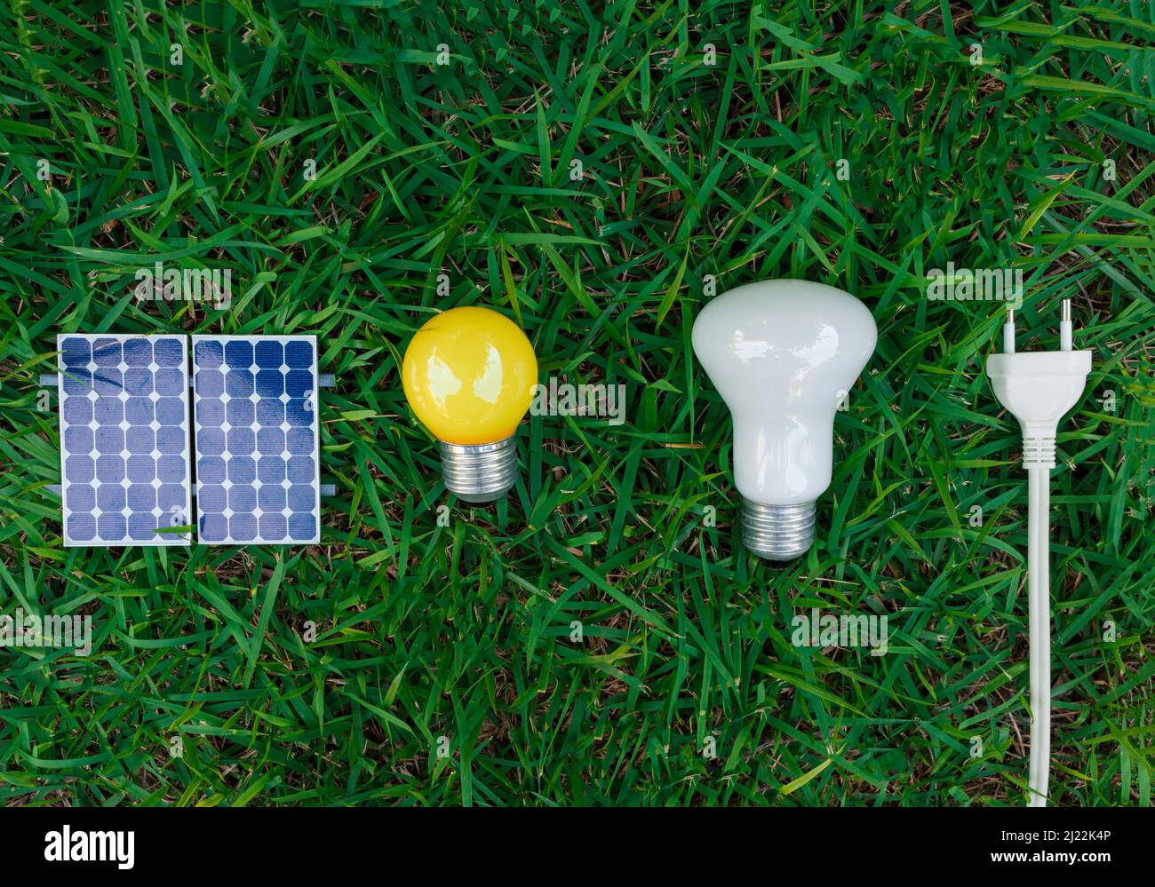 Photovoltaic solar panel, lamp, plug wire and mobile on green grass ...