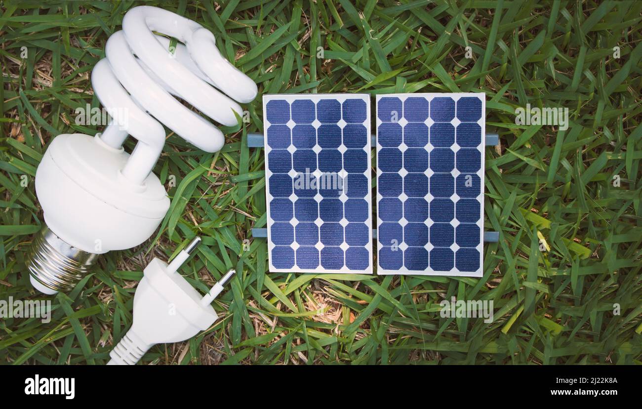 Photovoltaic solar panel, lamp, plug wire and mobile on green grass ...