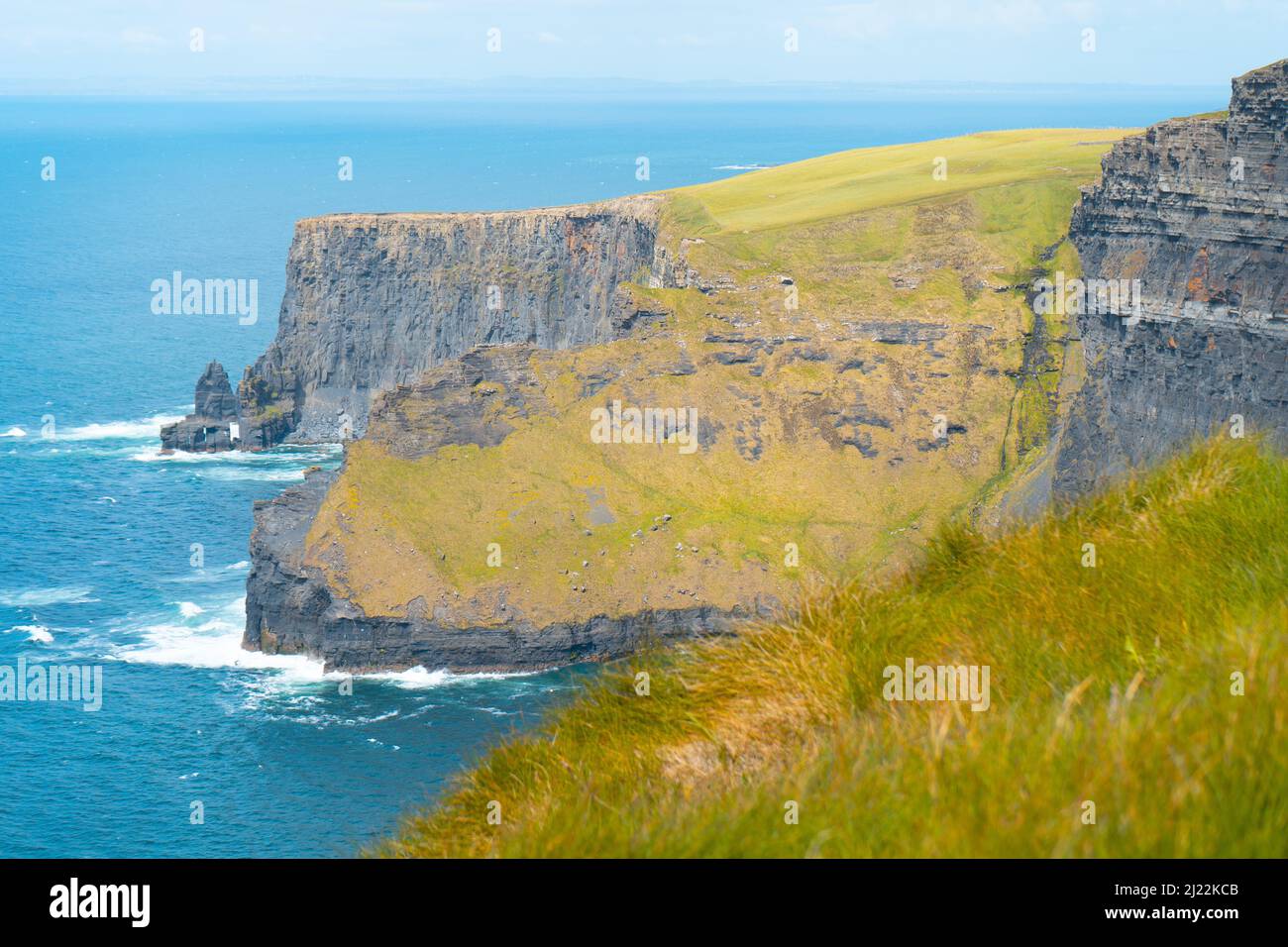 A scenic view of ocean waves crashing against the Cliffs of Moher in ...
