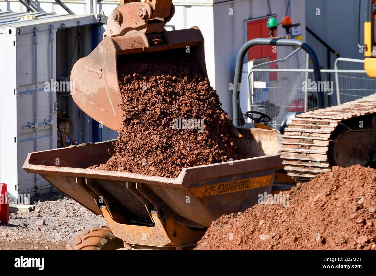 Taffs Well, Wales - March 2022: Mechanical digger tipping large gravel ... Taffs Well, Wales - March 2022: Mechanical digger tipping large gravel ...