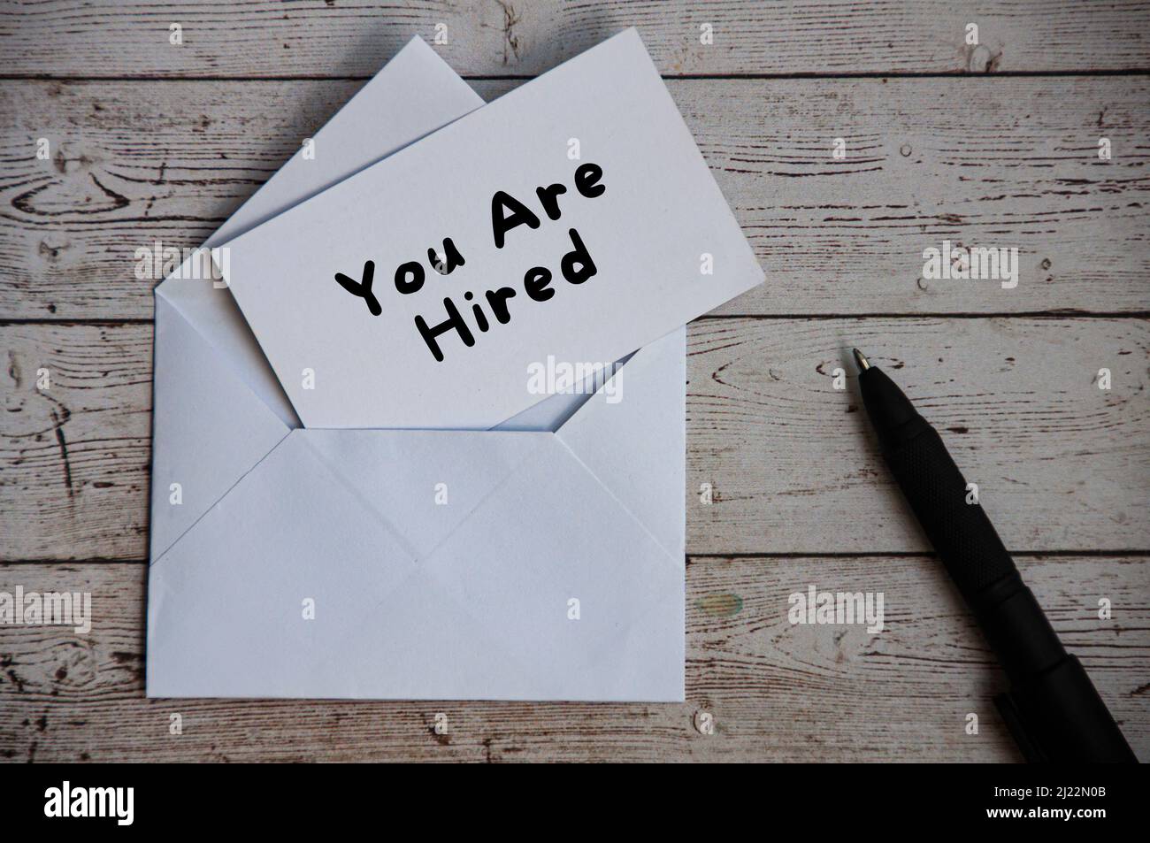 You are hired text on white notepad in an envelope. Employment concept ...