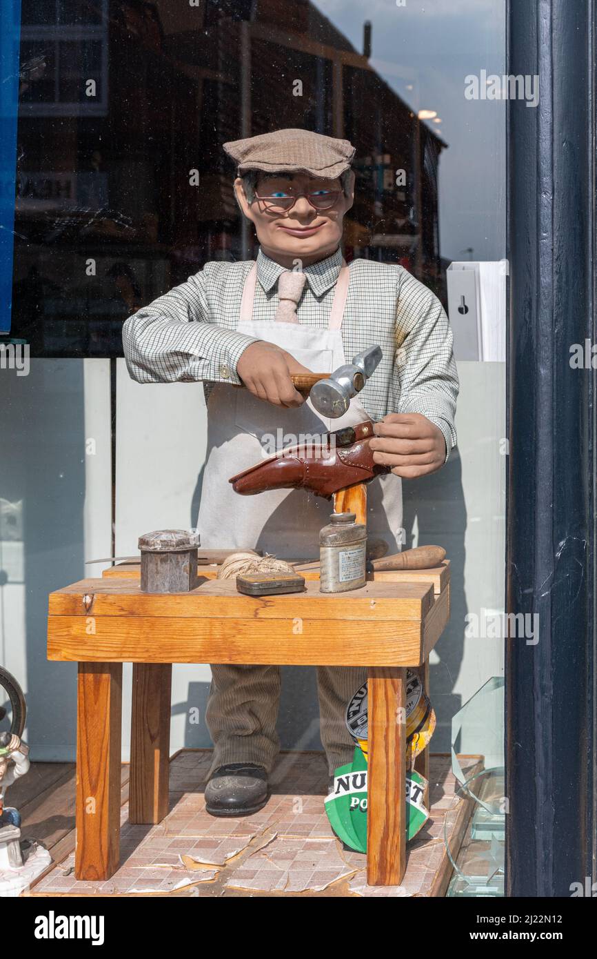 Shop window display in a traditional shoe repairers shop with a model ...