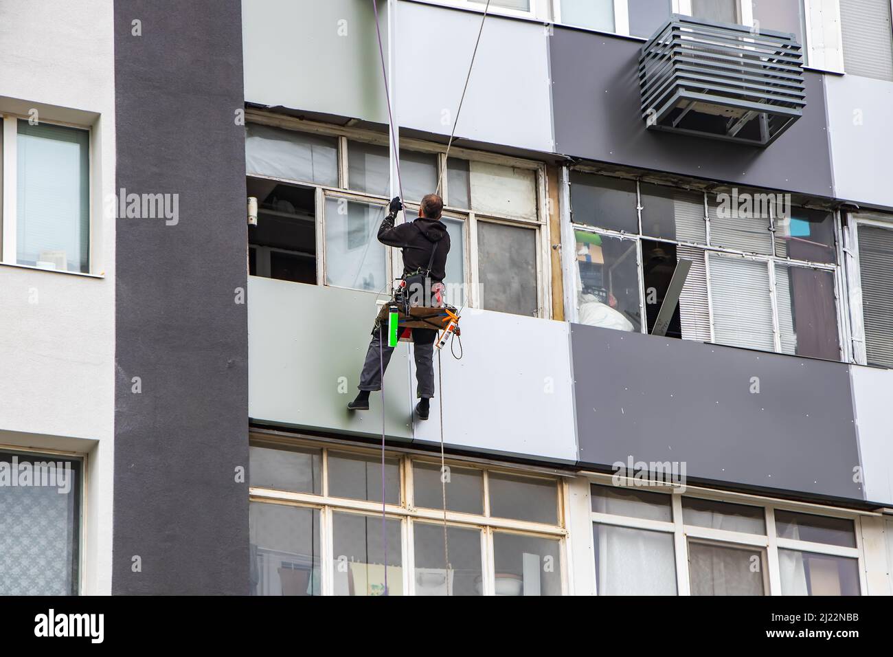 Facade worker plastering external wall of building Stock Photo - Alamy