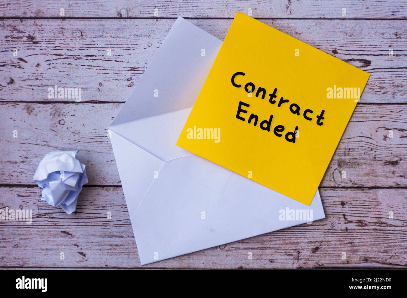 Contract ended text on yellow notepad with envelope background ...