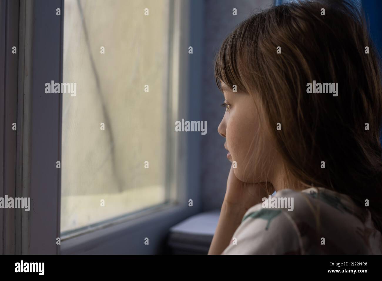 Little sad girl near window. Abuse of children concept Stock Photo - Alamy